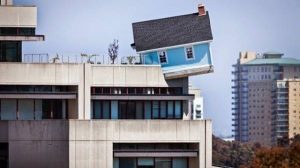 Fantastic Small House Design Balancing on Edge of Large Building